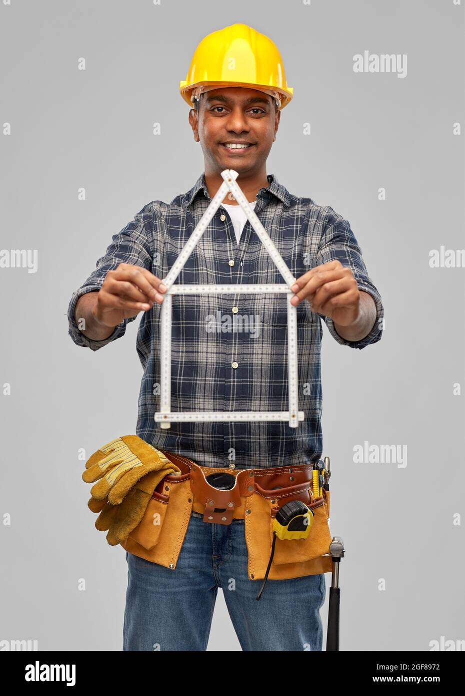 happy indian builder with ruler in shape of home Stock Photo - Alamy