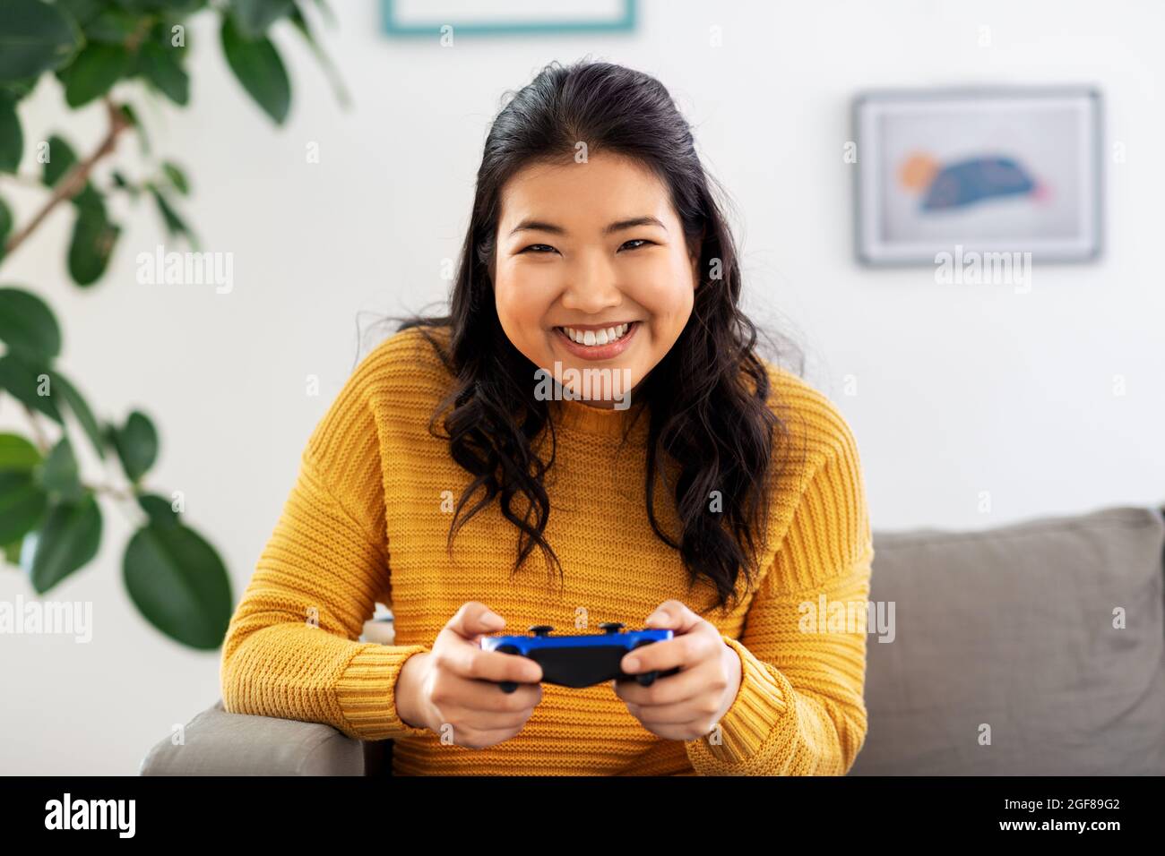 asian woman with gamepad playing game at home Stock Photo - Alamy