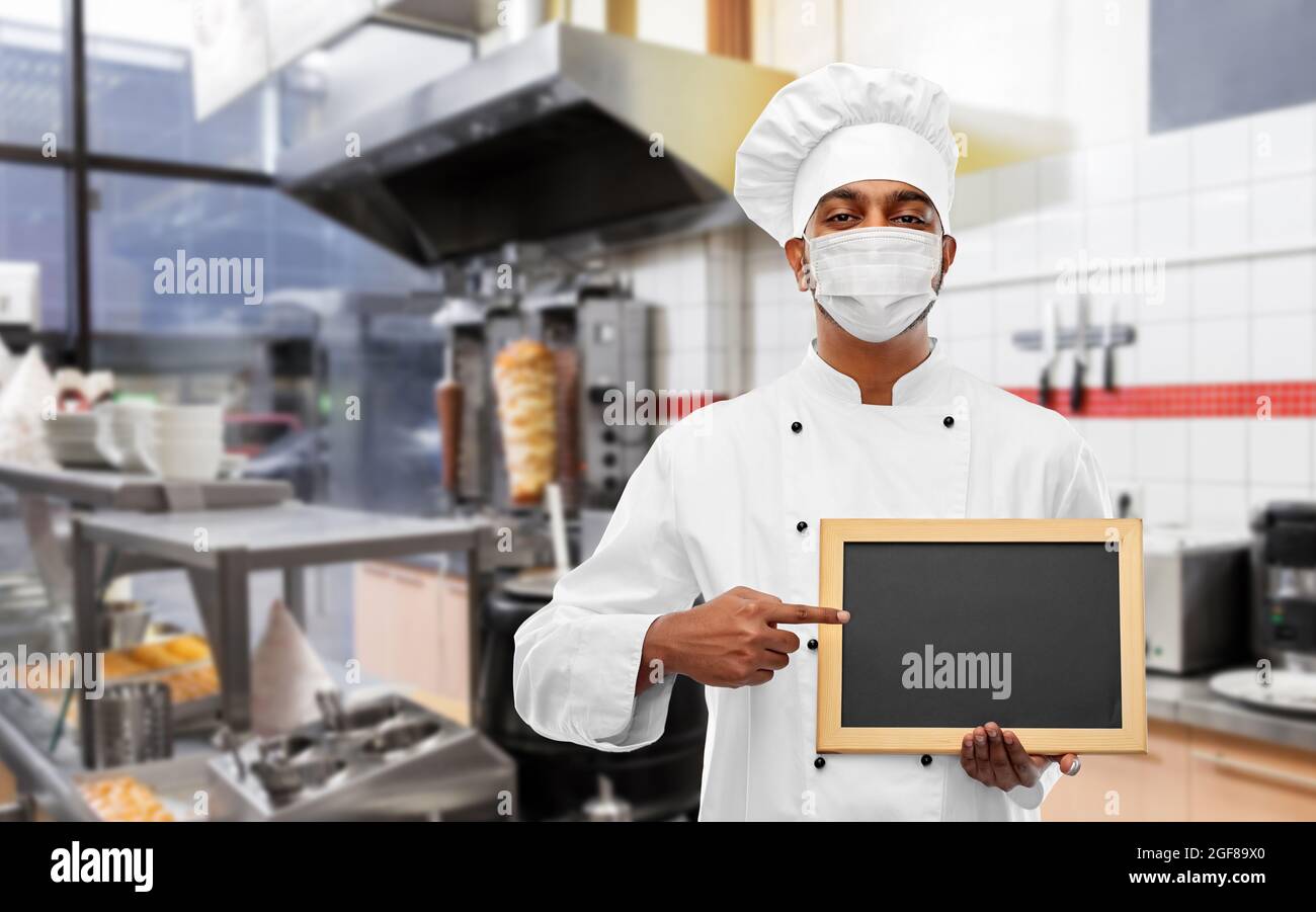chef in face mask with chalkboard at kitchen Stock Photo - Alamy