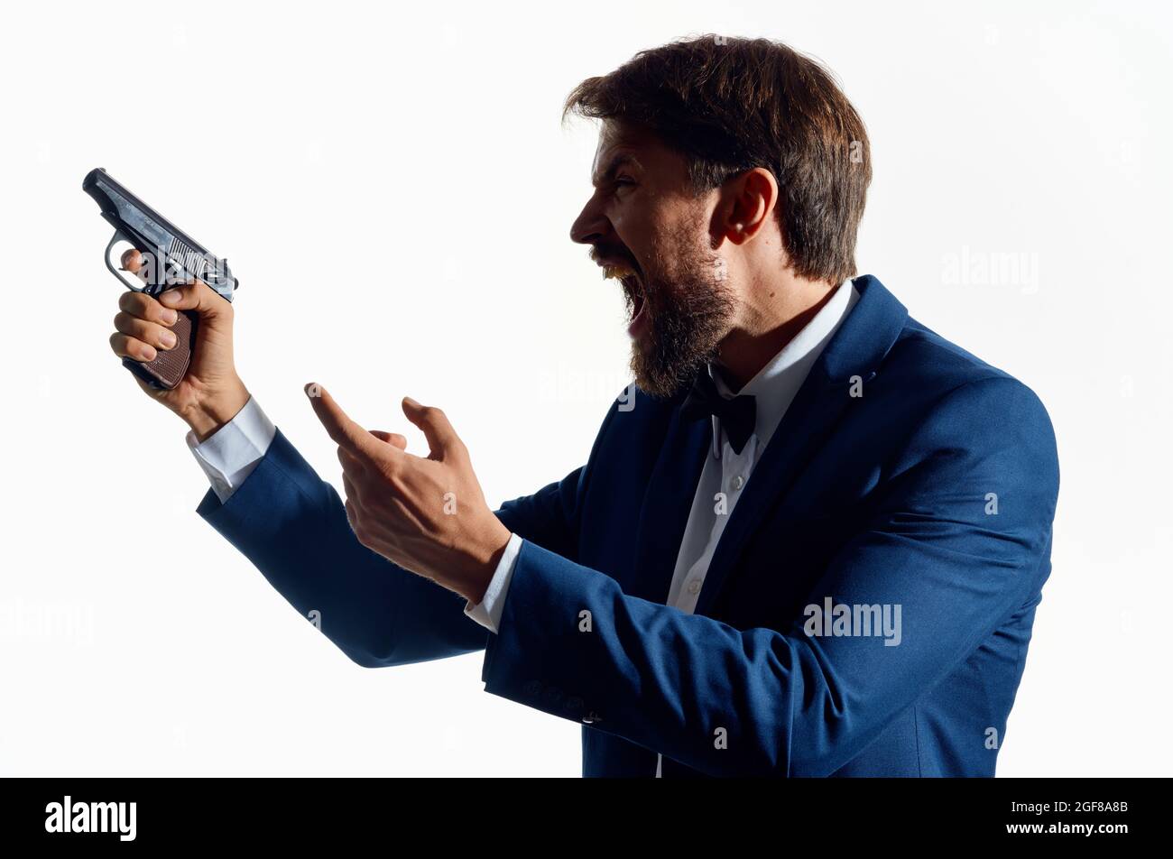 male gangster with a gun in hand light background Stock Photo - Alamy