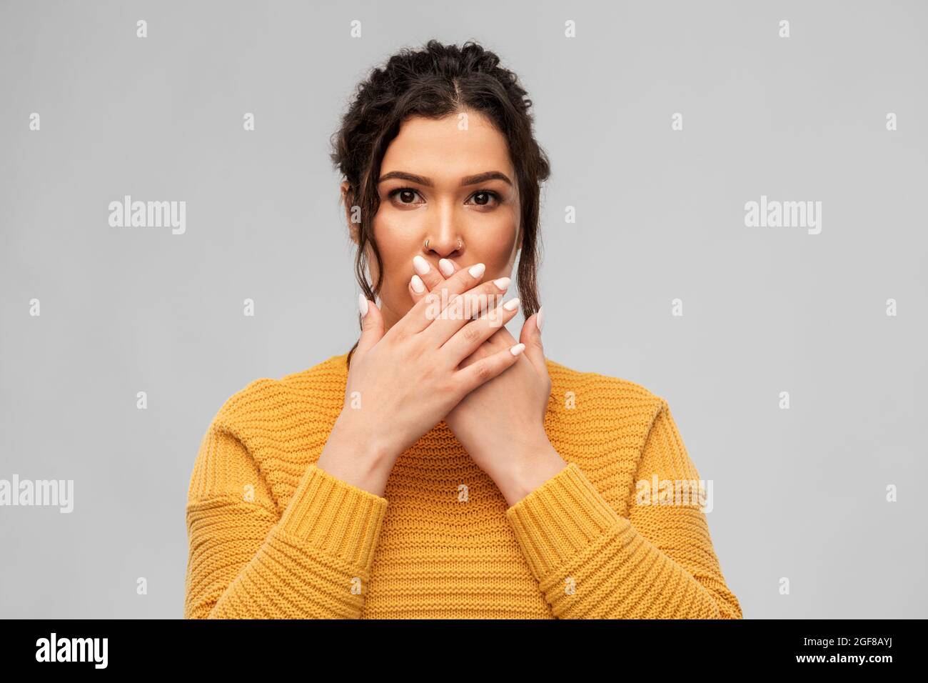 scared woman clothing her mouth with hands Stock Photo - Alamy