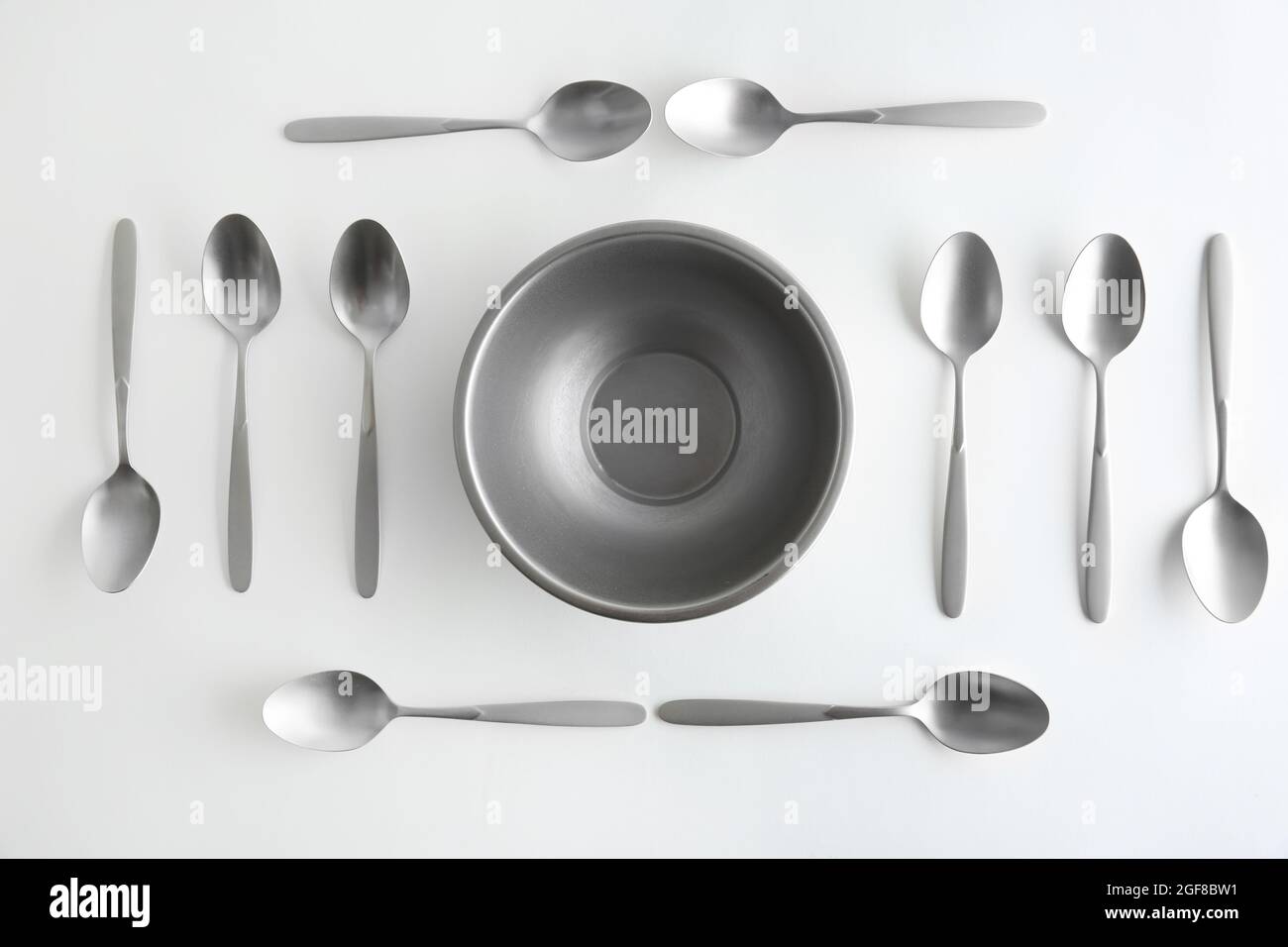 Plate and silver spoons, top view Stock Photo - Alamy