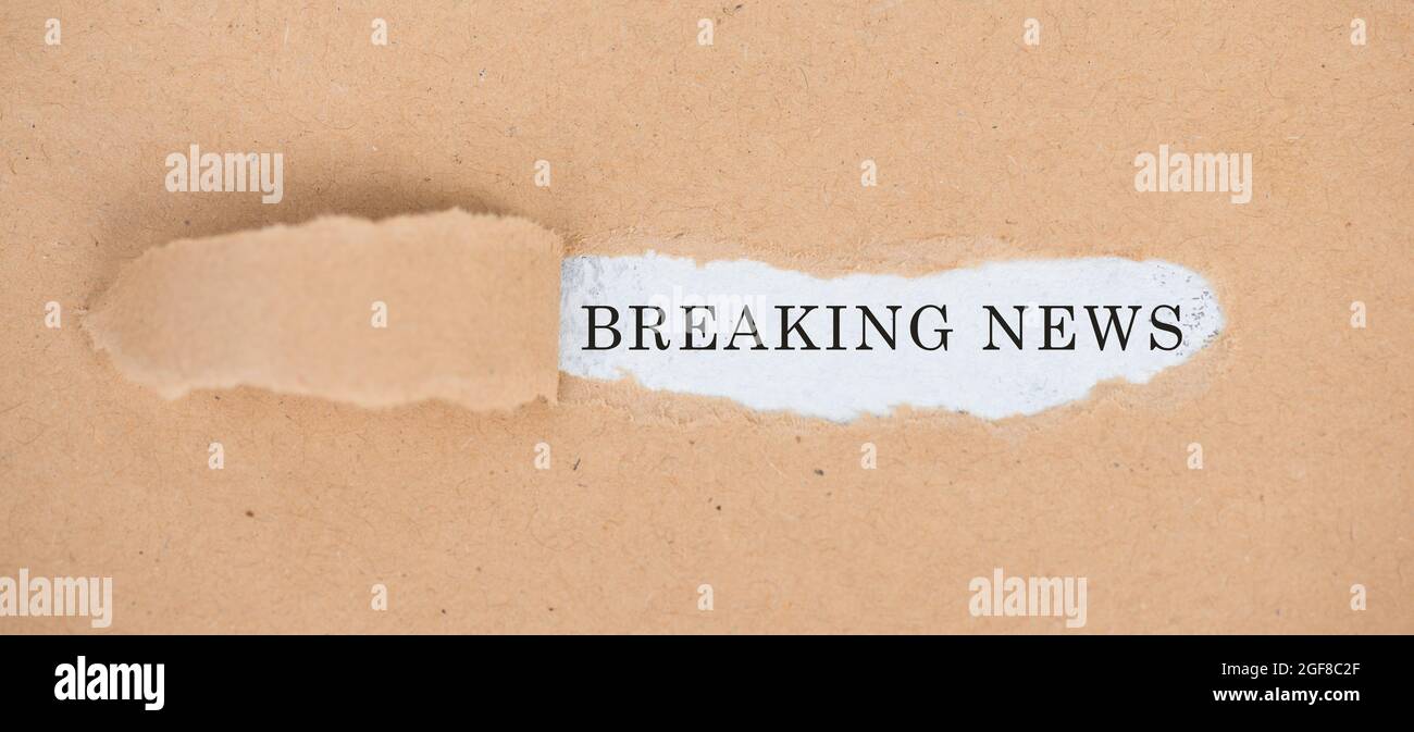 Breaking News standing on a ripped paper Stock Photo - Alamy