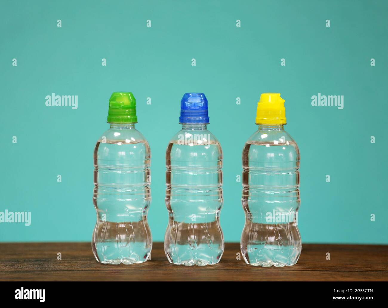 Three bottles of water on the blue background Stock Photo - Alamy