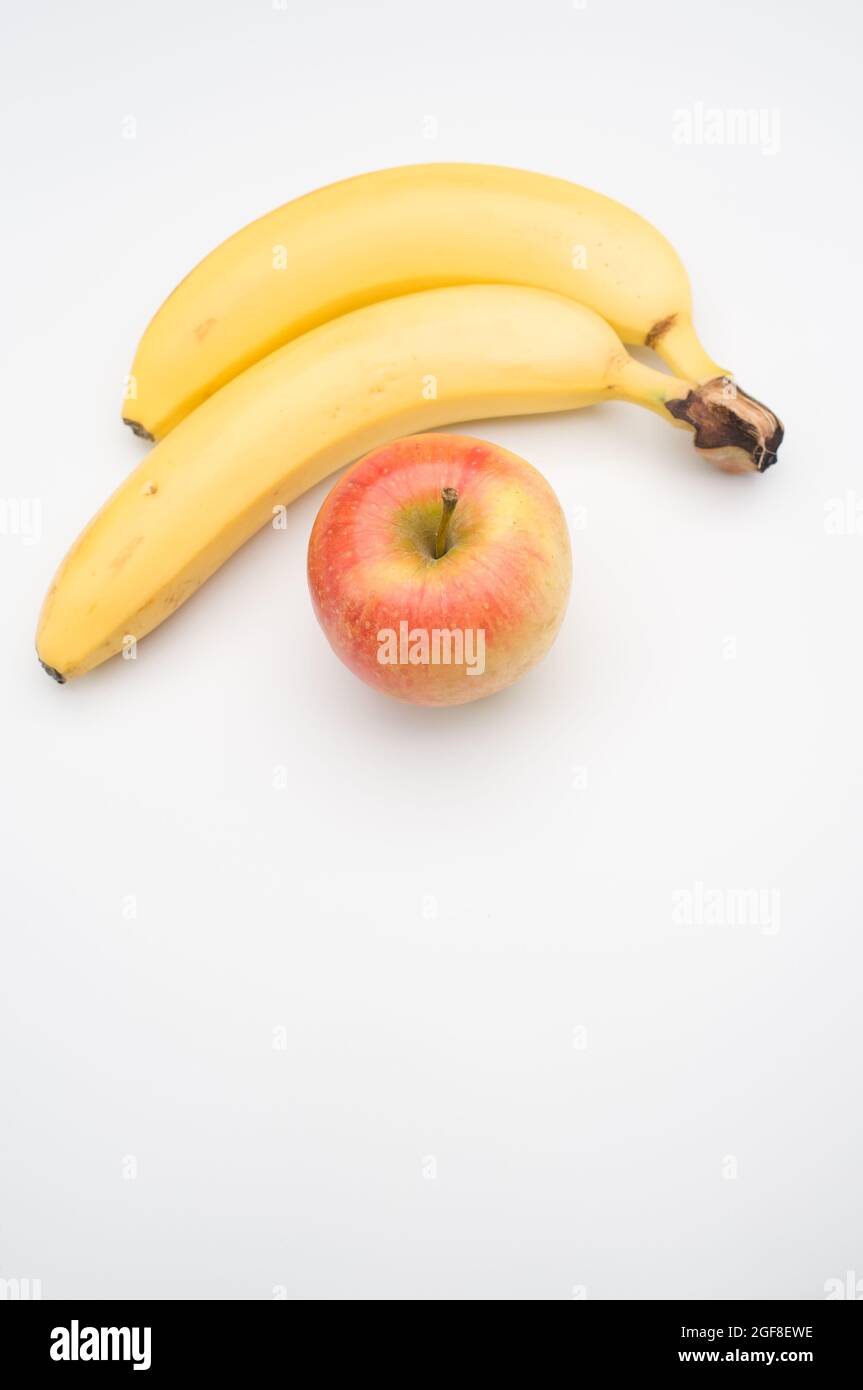 Closeup of the fresh tasty organic bananas with an apple on the white ...