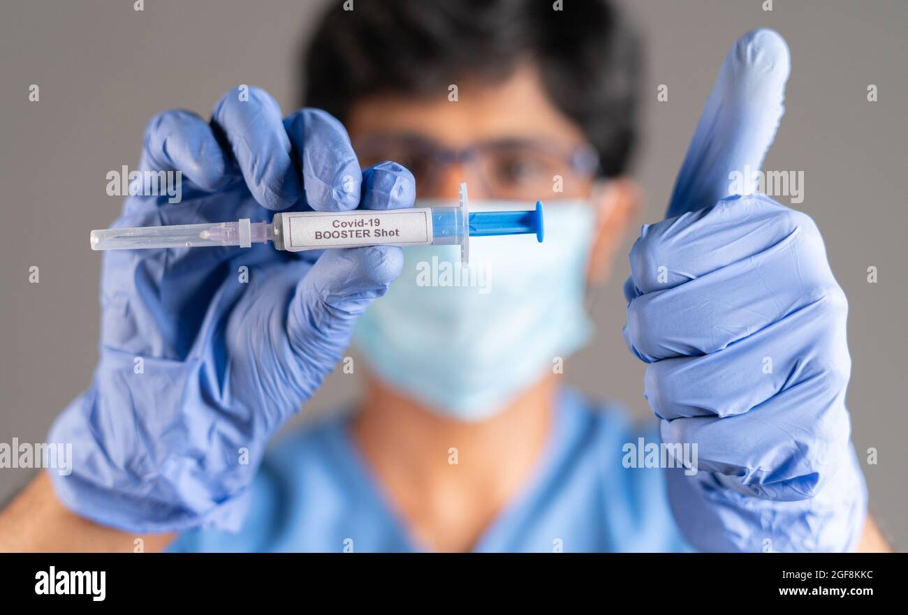 Close up of doctor hands with covid-19 booster shot syringe showing ...