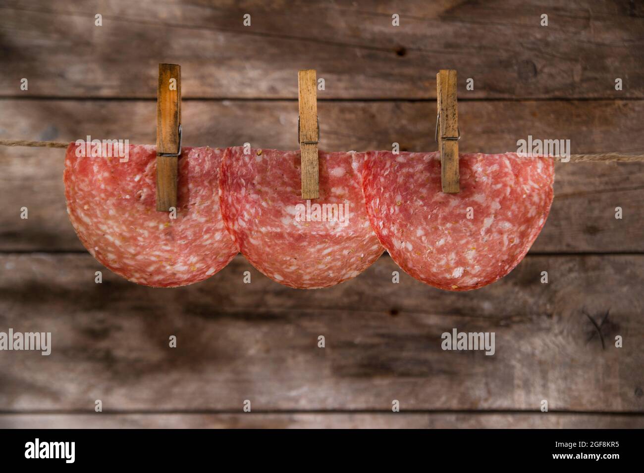 Presentation of slices of salami hanging by a thread Stock Photo - Alamy