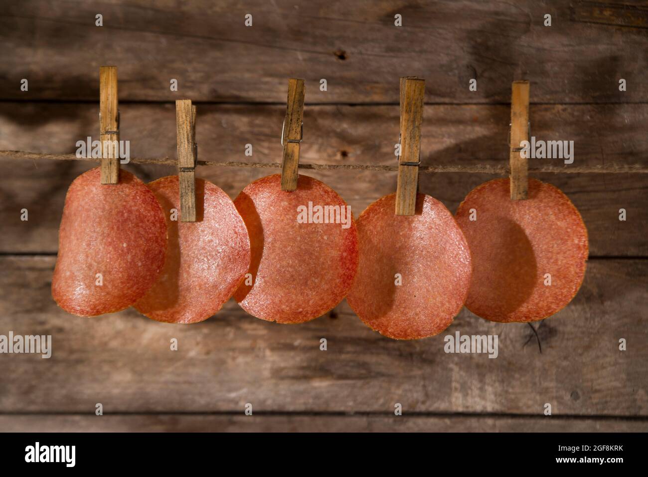 Presentation of slices of salami hanging by a thread Stock Photo - Alamy