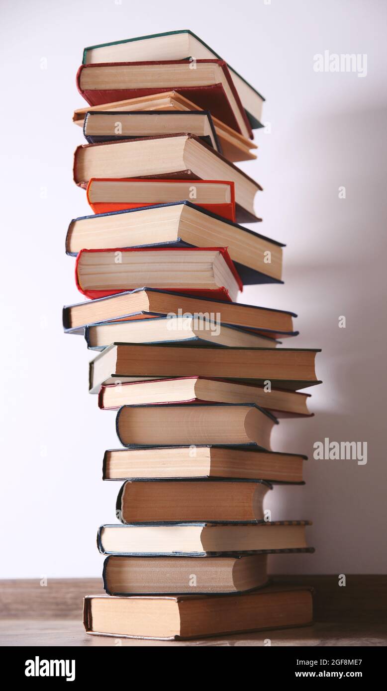 Pile of books on wall background Stock Photo - Alamy