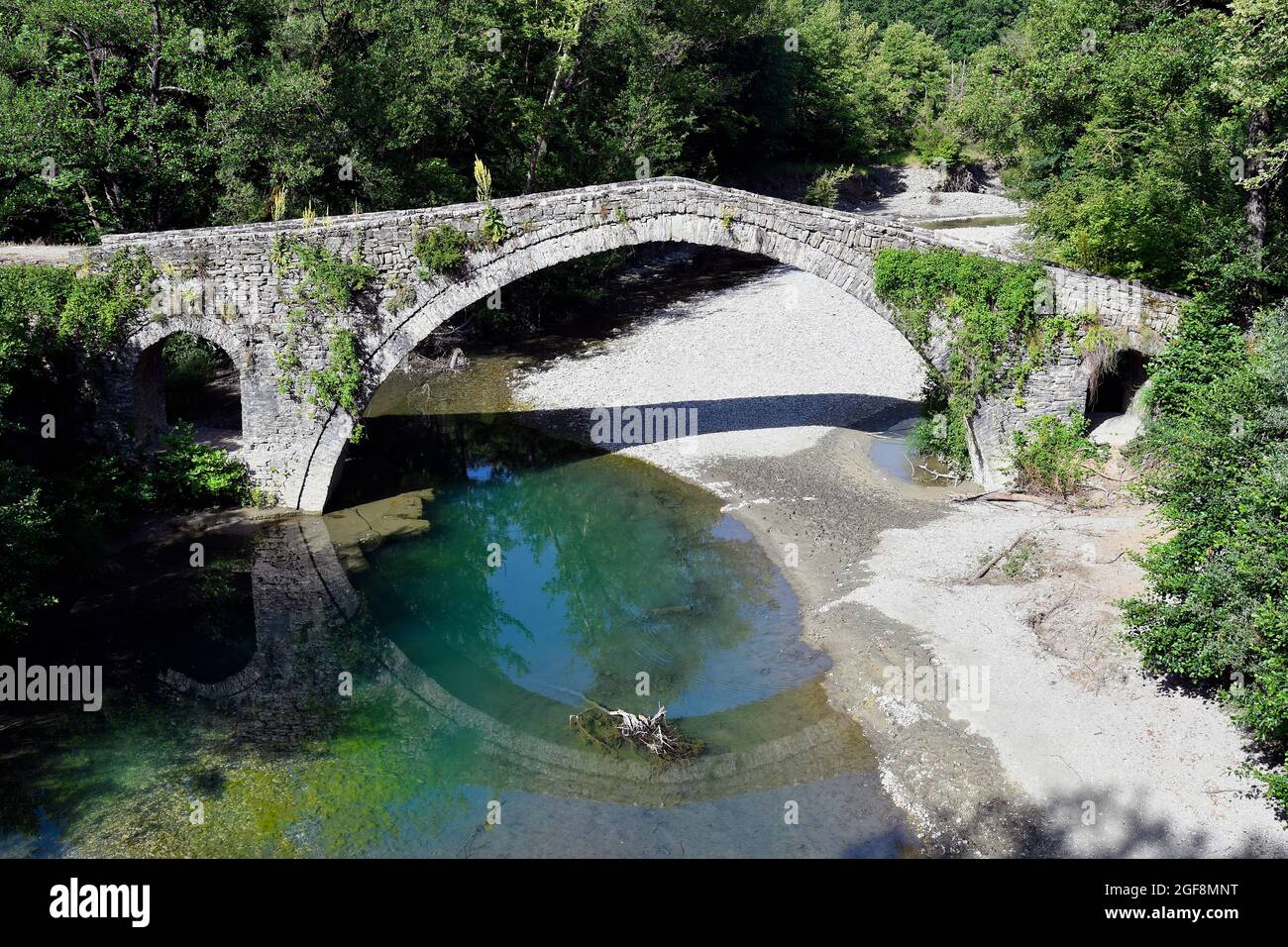 Greece, ancient stone bridge Kamber Aga aka Kamper Aga with reflection ...