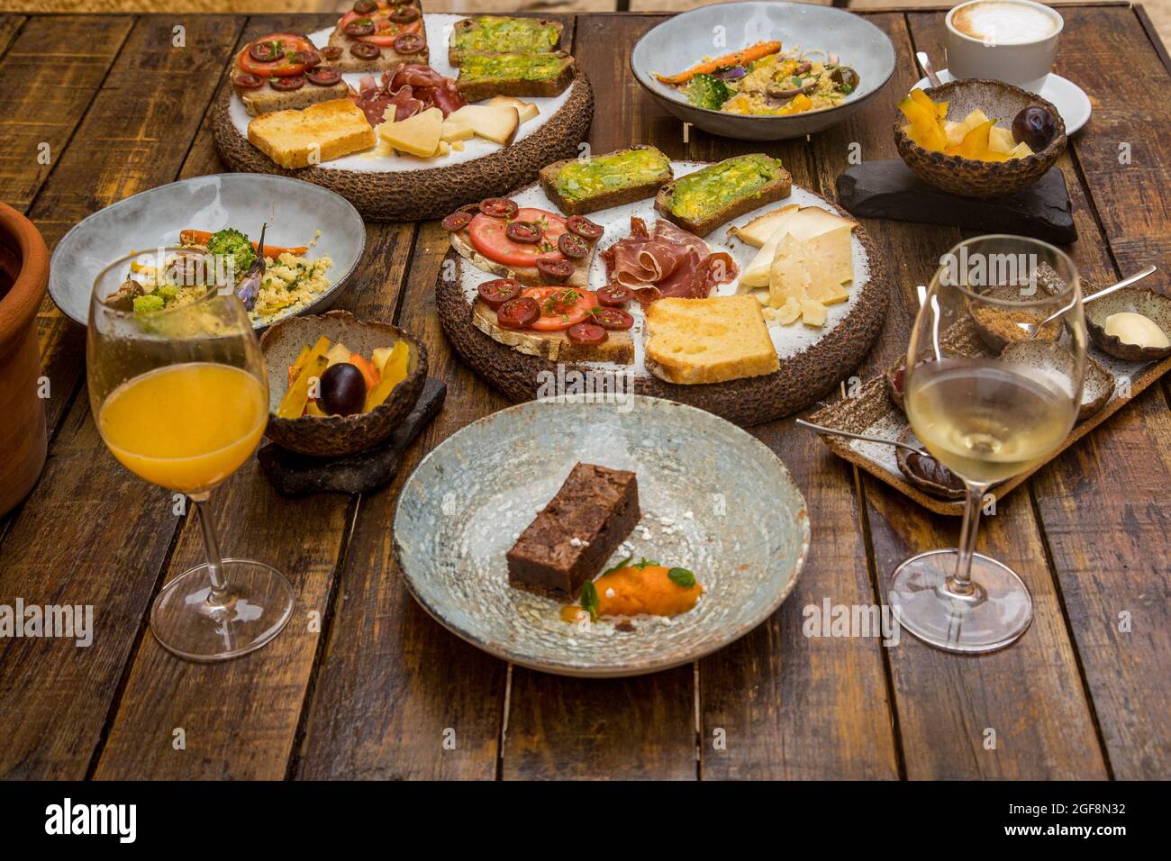 Wooden table full of different snacks and drinks on plates and bowls ...