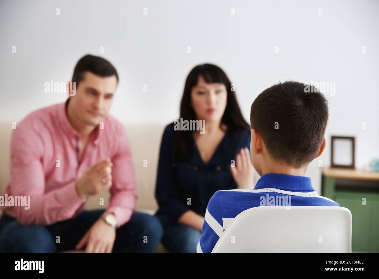 Parents berating their son indoors Stock Photo - Alamy