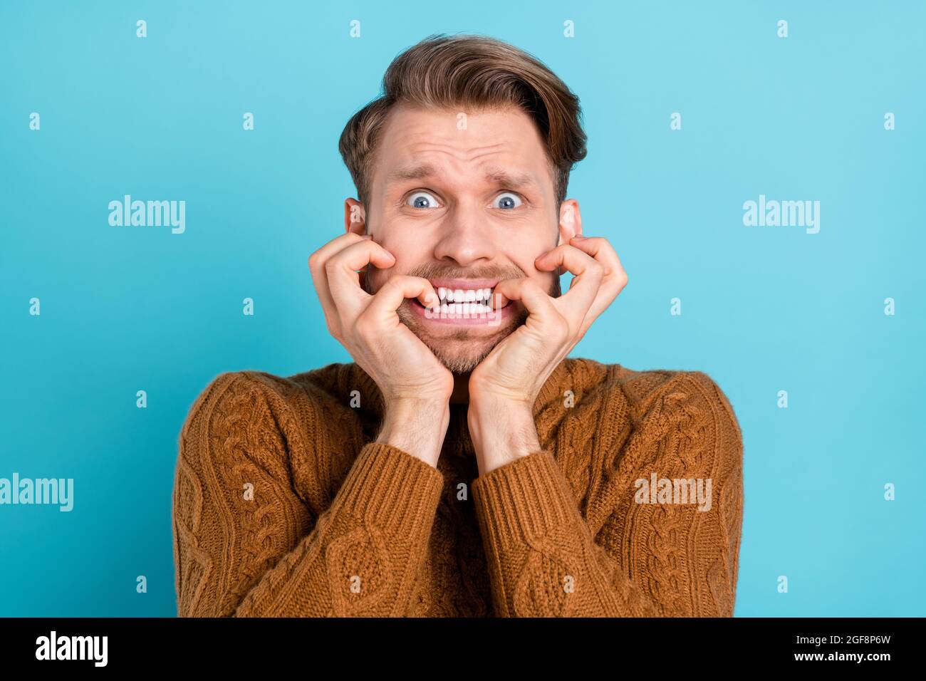 Photo of pretty scared young gentleman wear brown pullover biting ...