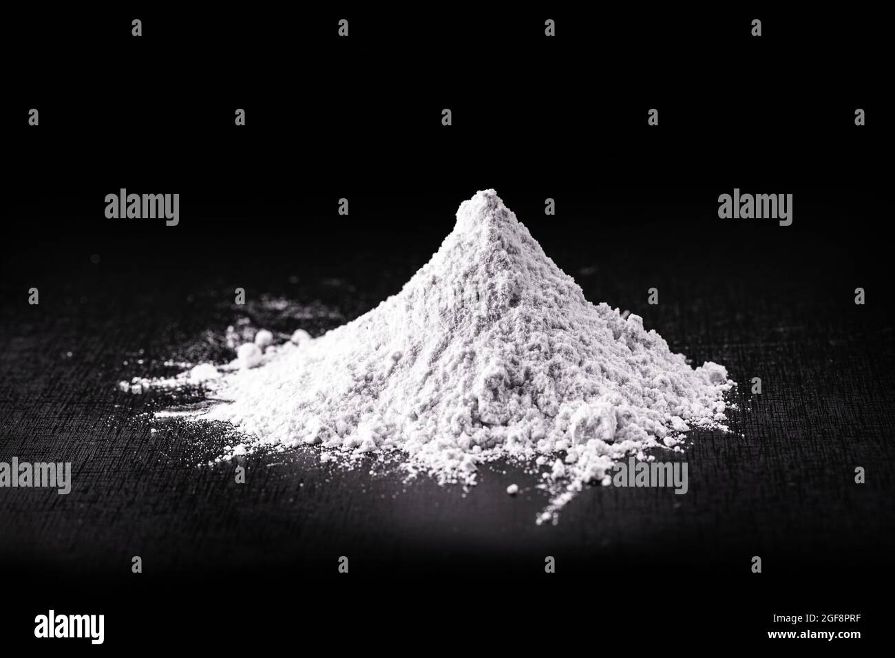 Titanium dioxide (TiO2) powder for cosmetics, isolated black background ...
