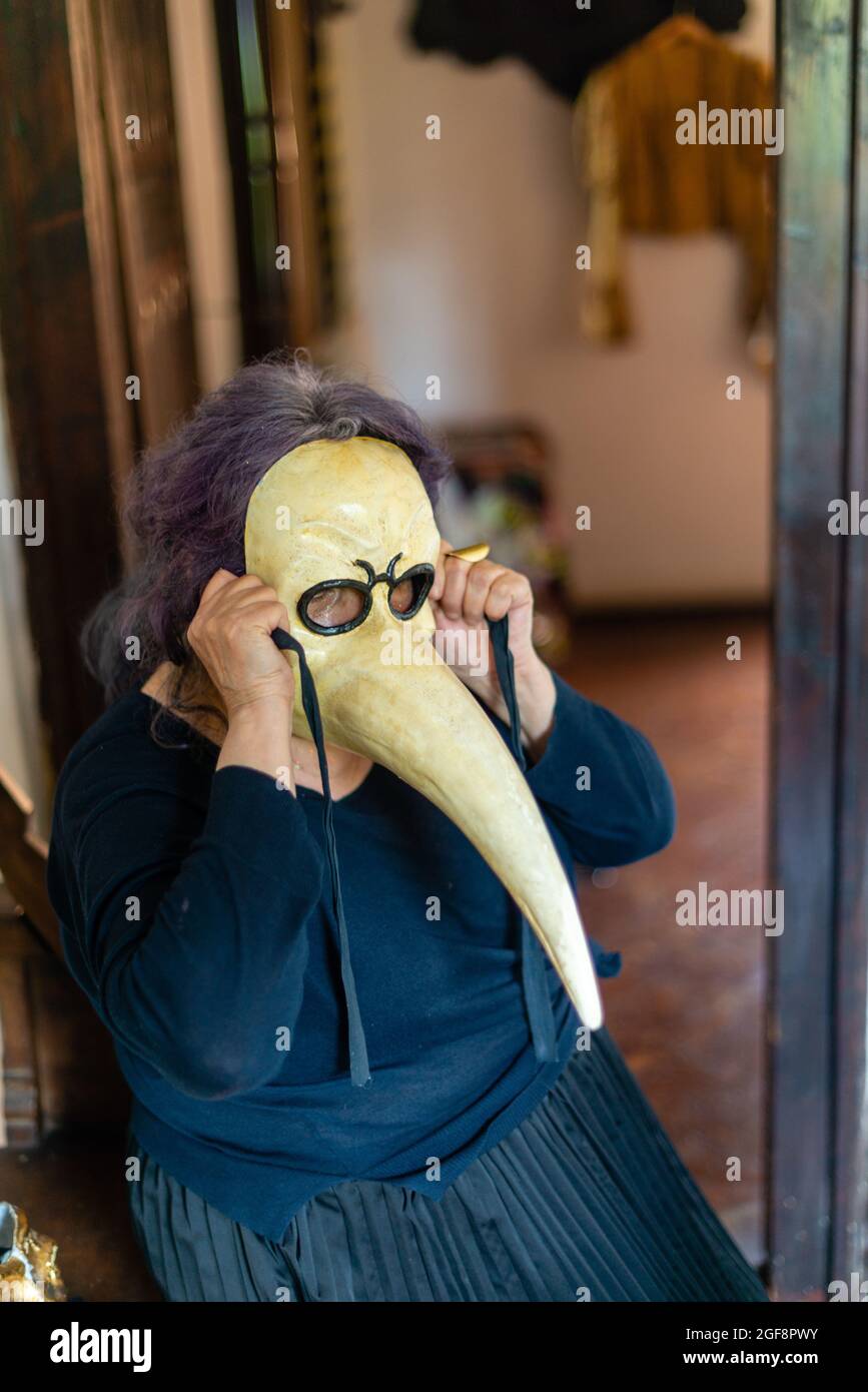 Elderly woman wearing a scary mask with a long nose Stock Photo - Alamy