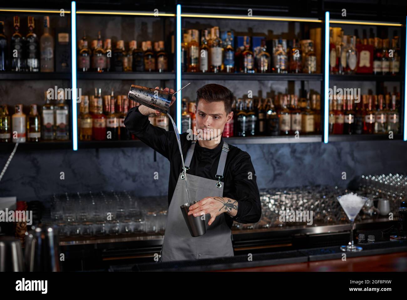 barman is making cocktail with steel shaker Stock Photo - Alamy