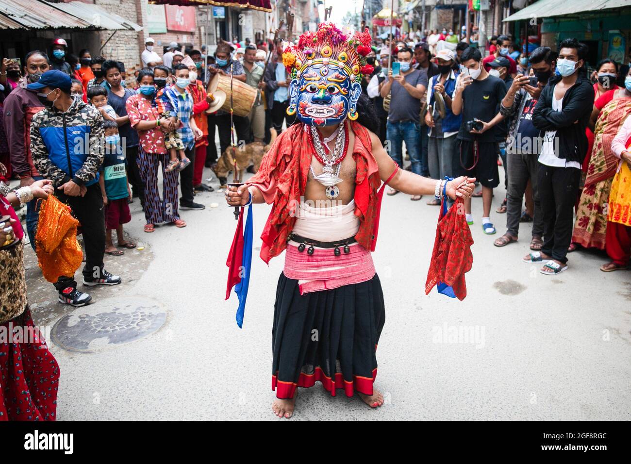 A devotee dressed up as a deity take part in a traditional procession ...