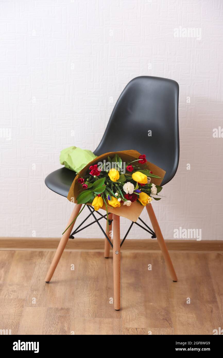 Bouquet of fresh flowers on the chair by the wall Stock Photo - Alamy