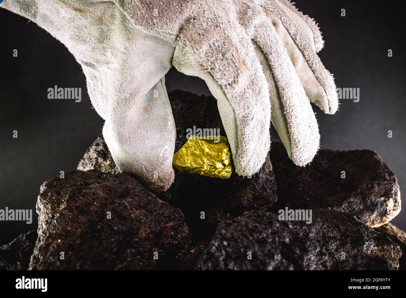 gold nugget in a miner's hand, hidden gold stone Stock Photo - Alamy