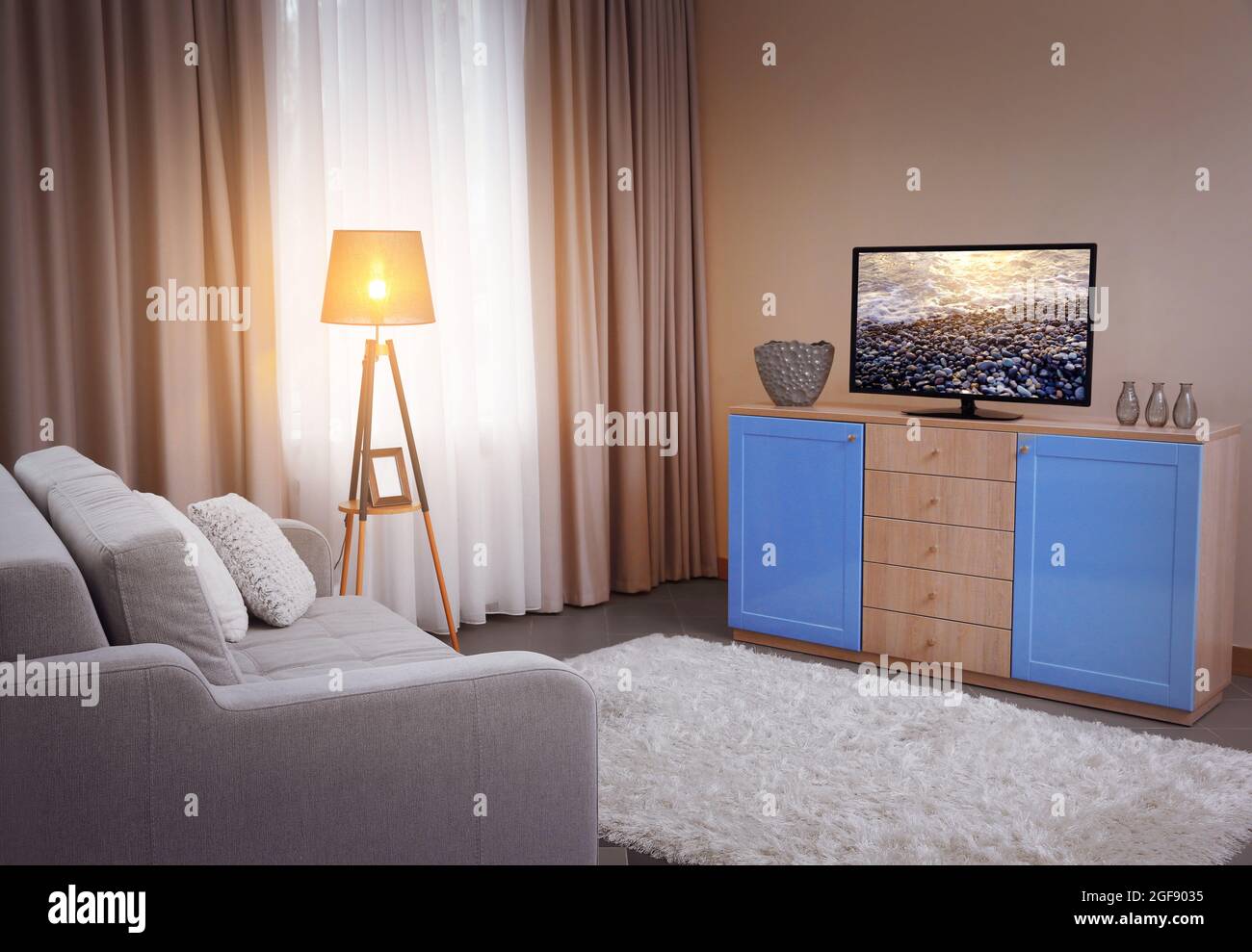 Modern living room with couch and TV Stock Photo - Alamy