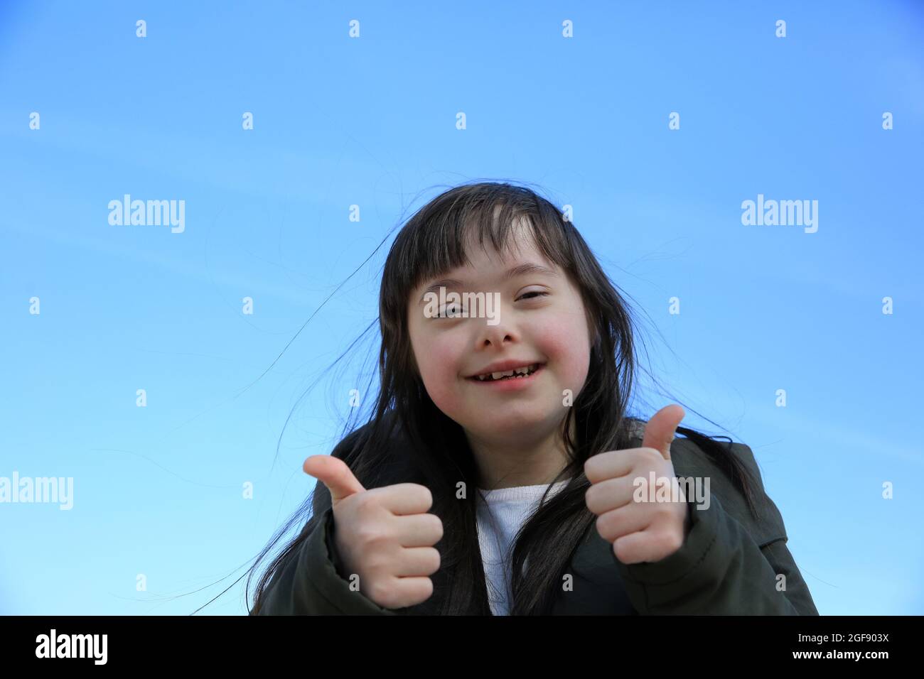 Portrait of little girl smiling on background of the blue sky Stock ...
