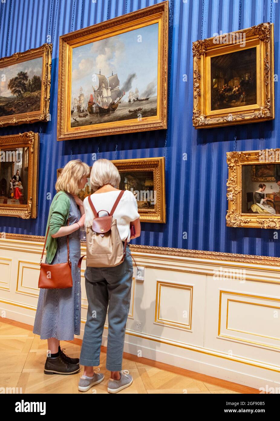 Museum-goers looking at paintings in The Wallace Collection, Hertford ...