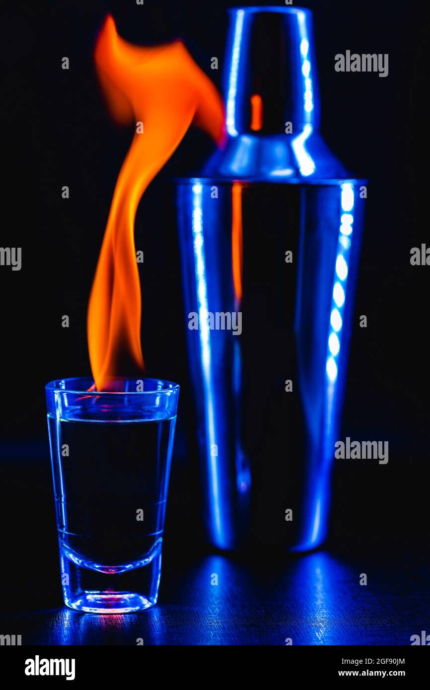 glass of flaming alcoholic drink, vodka or liquor on fire, black ...