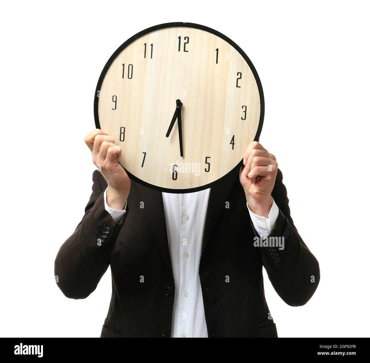 Man in black suit covering his face with big clock on white background ...