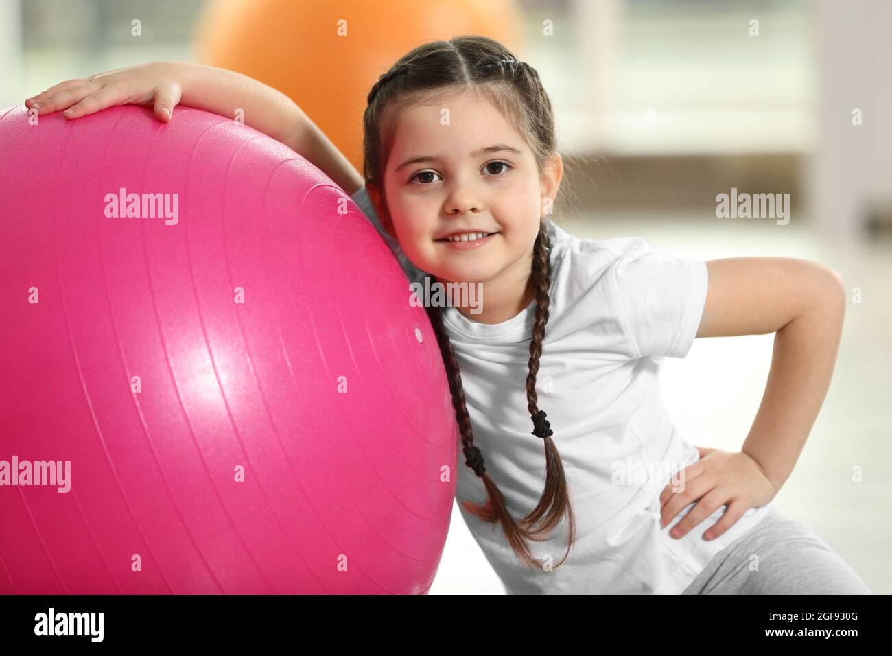 Little cute girl with exercise ball indoor Stock Photo - Alamy