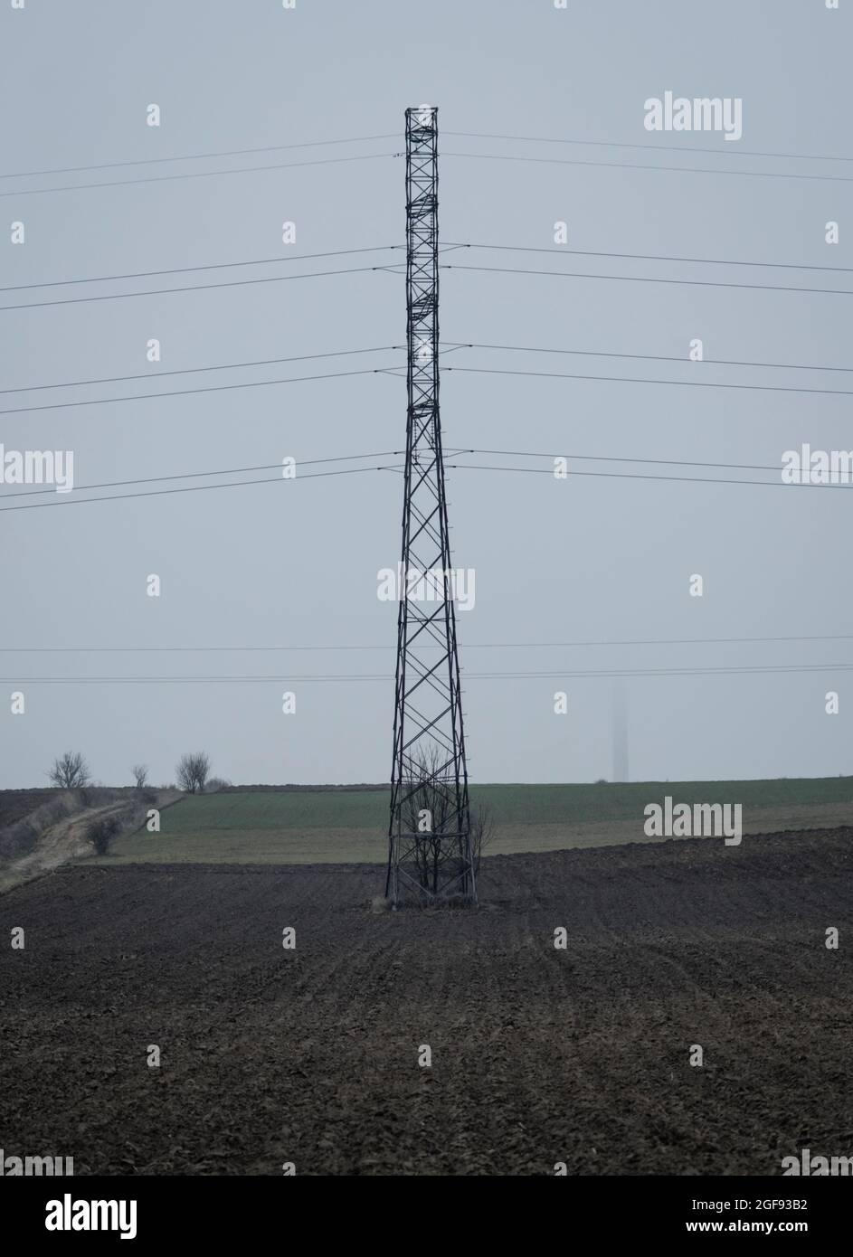single pylon with power lines in the middle of an empty field during ...