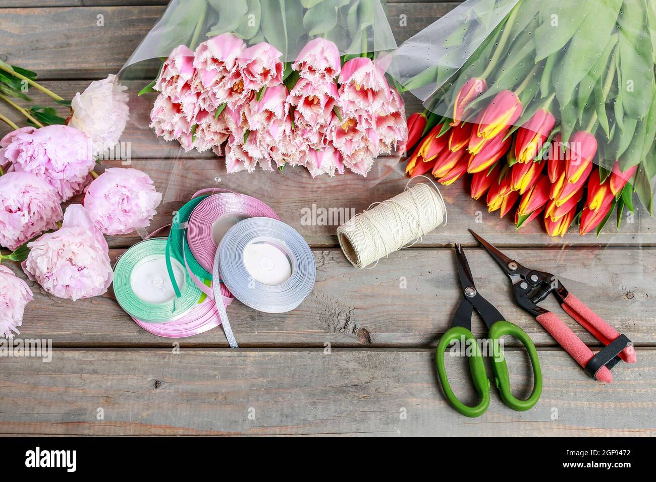 Florist workplace: flowers and accessories on wooden table. Top view ...