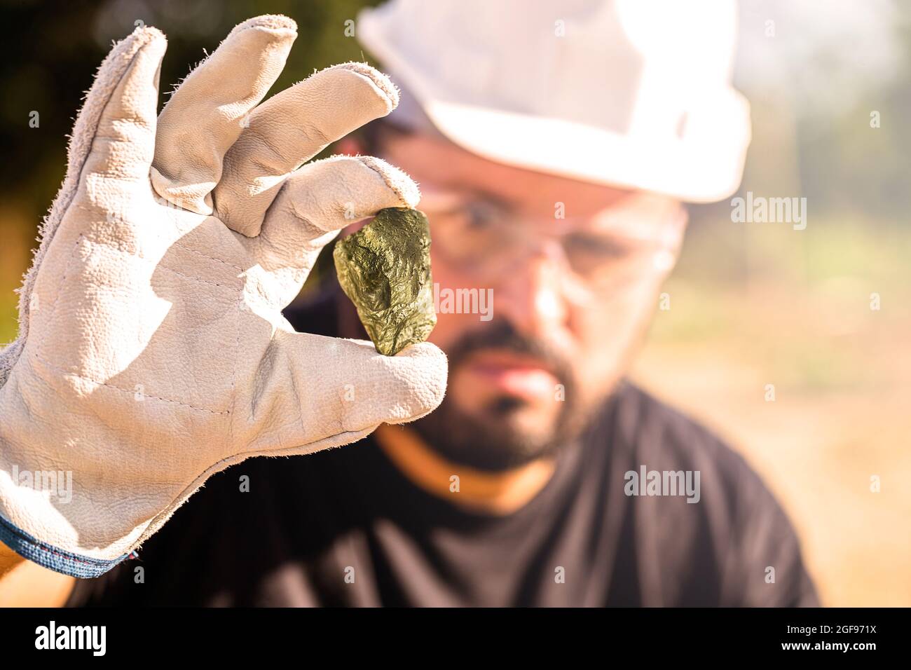 miner holding gold nugget, point focus on the gemstone. Mineral ...
