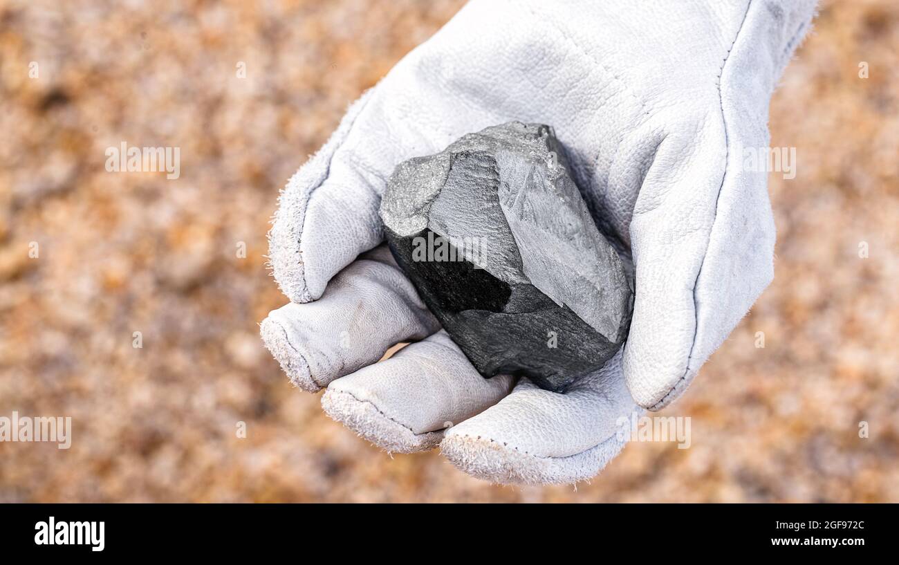 miner hand holding iron stone, metallic iron pyrite, steel, used in ...
