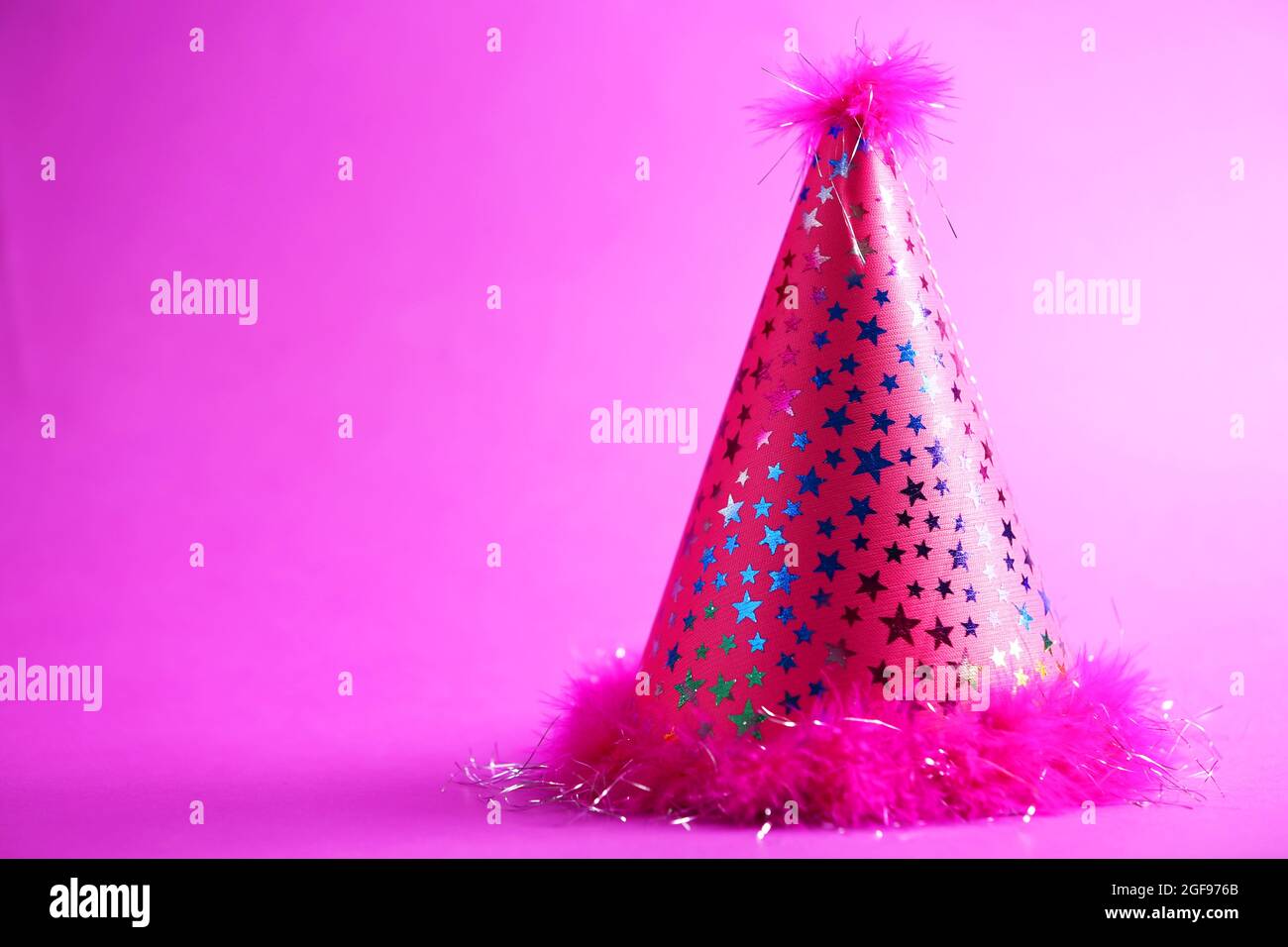 Funny party hat on pink background Stock Photo - Alamy