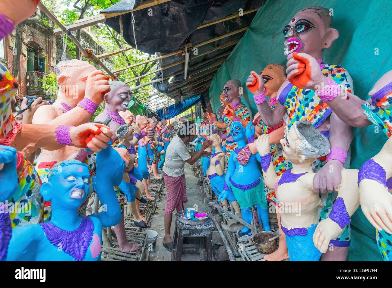 KUMARTULI, KOLKATA, INDIA - OCTOBER 10, 2014 - Artist preparing clay ...