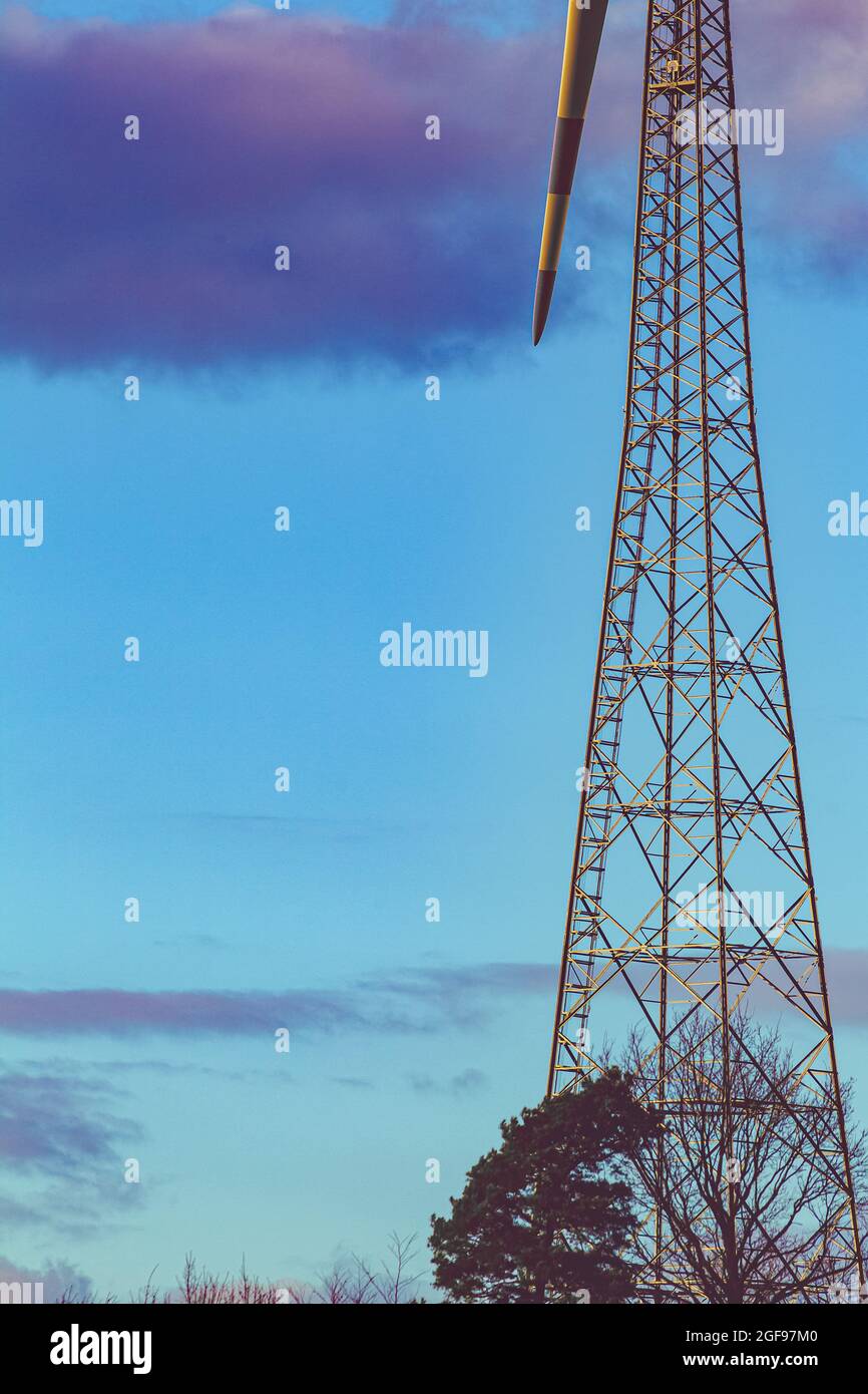 Vertical shot of a power technology tower with dark blue cloudy sky ...