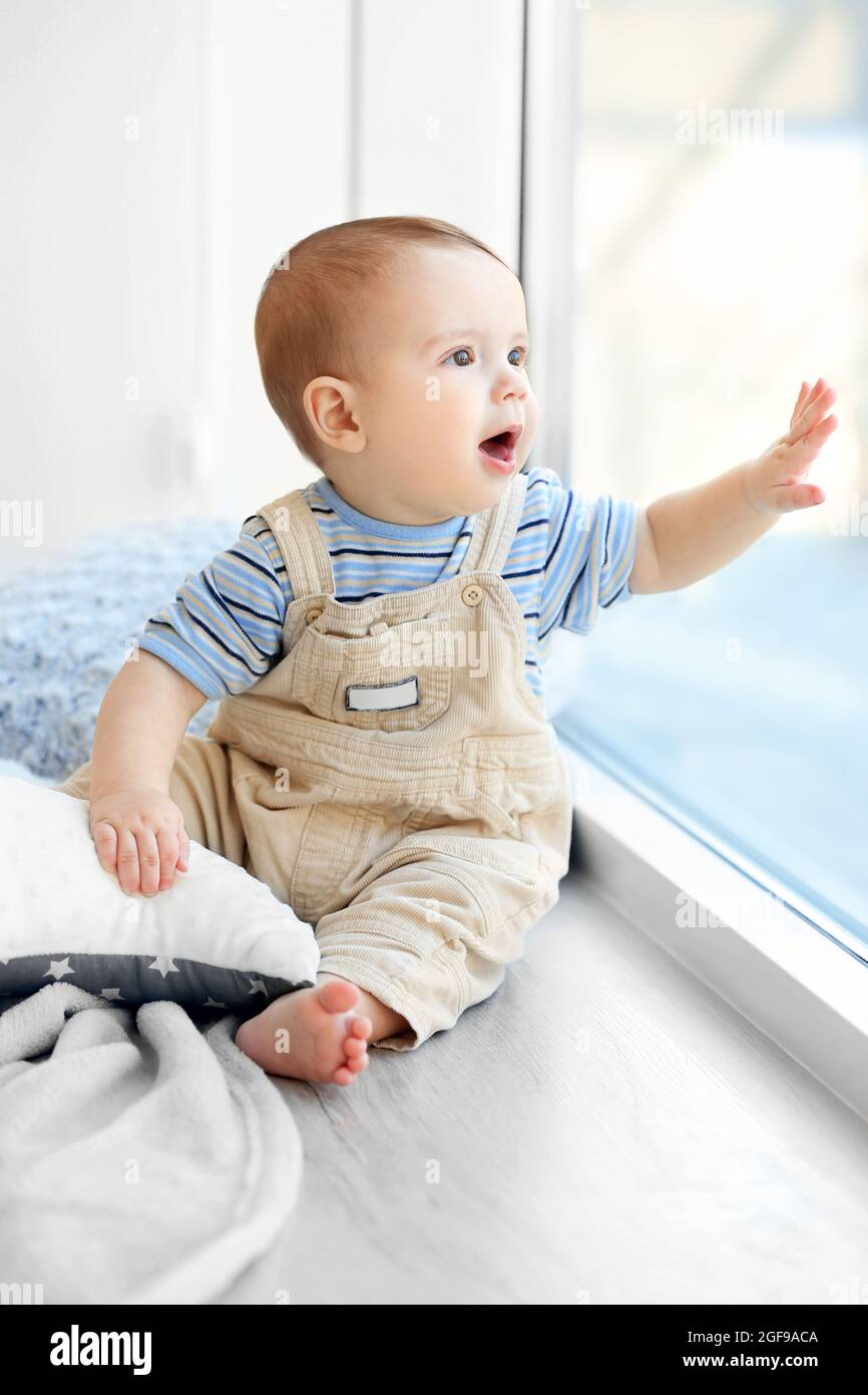 Little baby boy looking out the window at home Stock Photo - Alamy