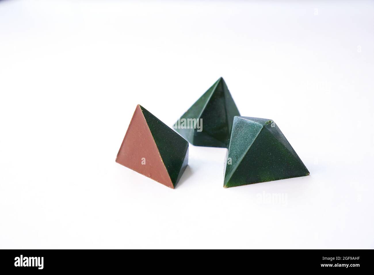 Luxury pyramid shaped chocolate candy. Three chocolates - green color ...