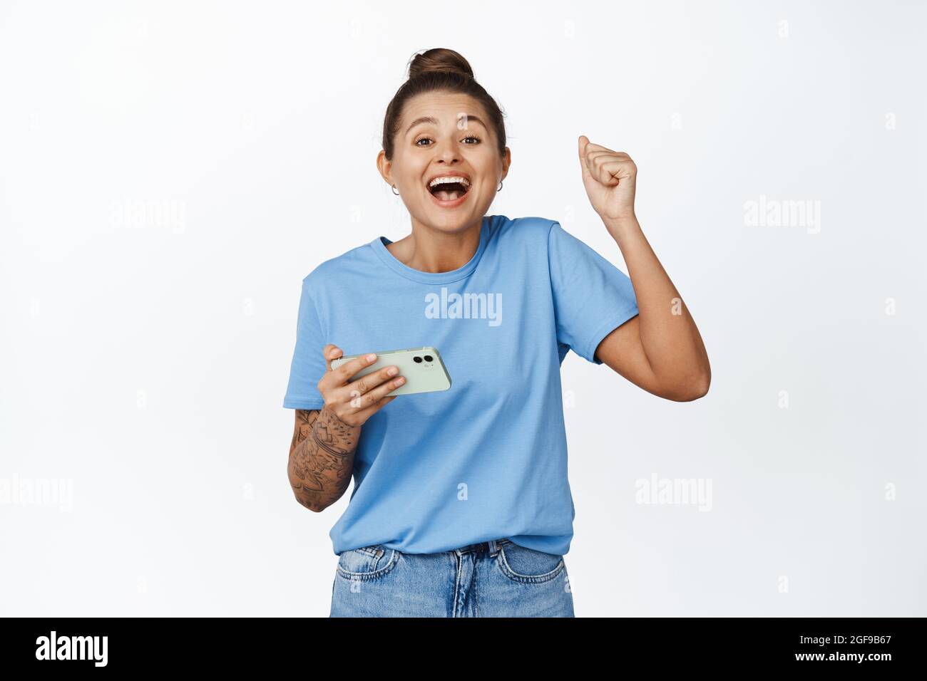 Happy girl winning on mobile phone, laughing and shouting with joy ...