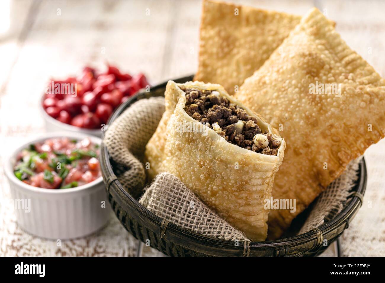 Fried pastry filled with ground meat and potatoes, hot sauce served hot ...