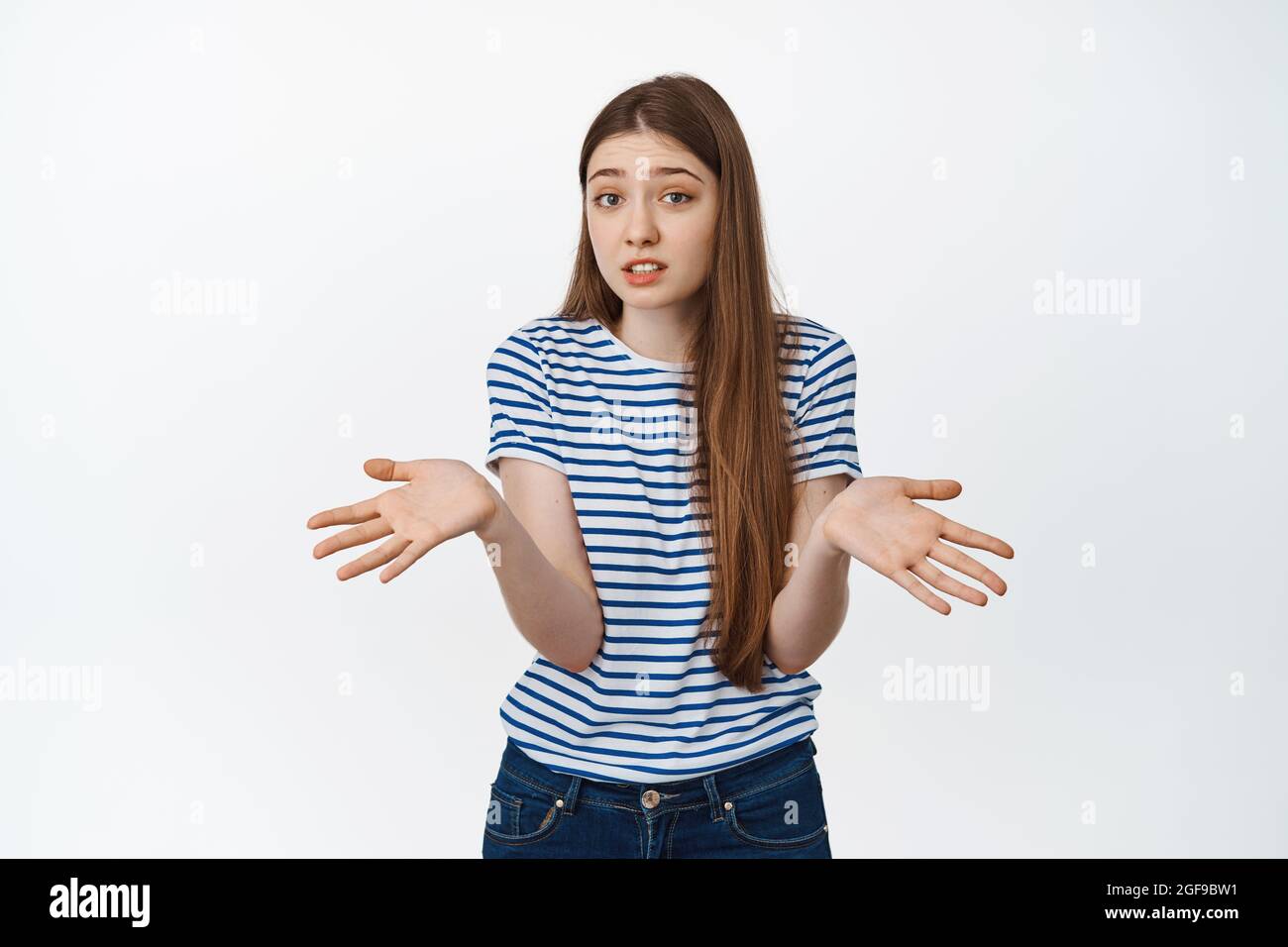 Awkward young woman showing empty hands and shrugging, has nothing ...