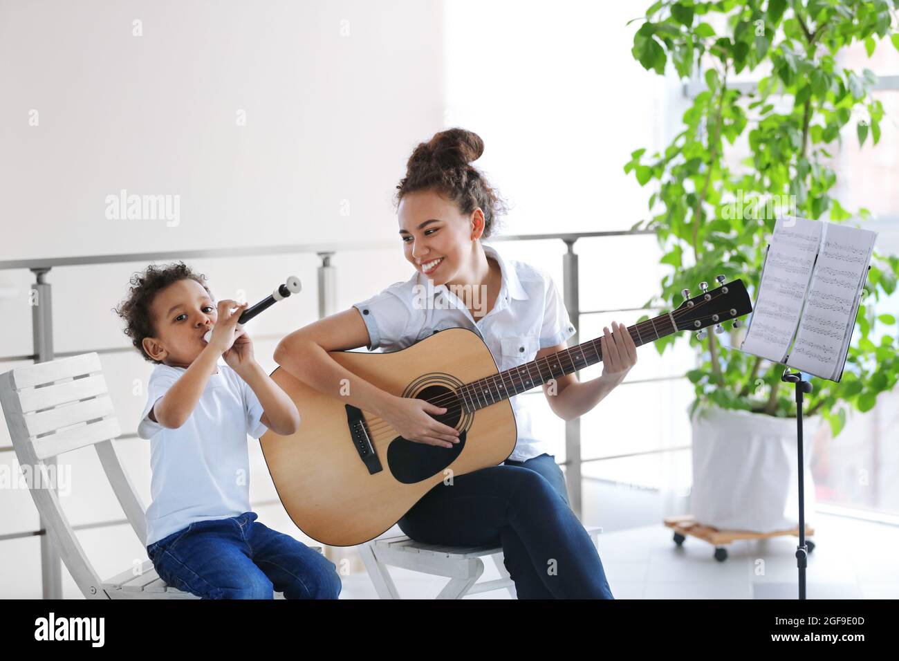 Young girl and little boy playing on music instruments Stock Photo - Alamy