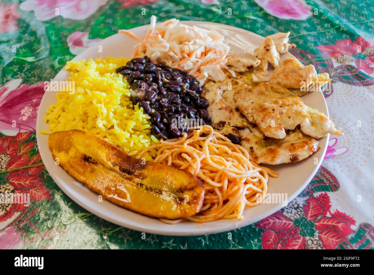 Meal in Venezuela. Rice and beans, plantain, pasta, meat and salad ...