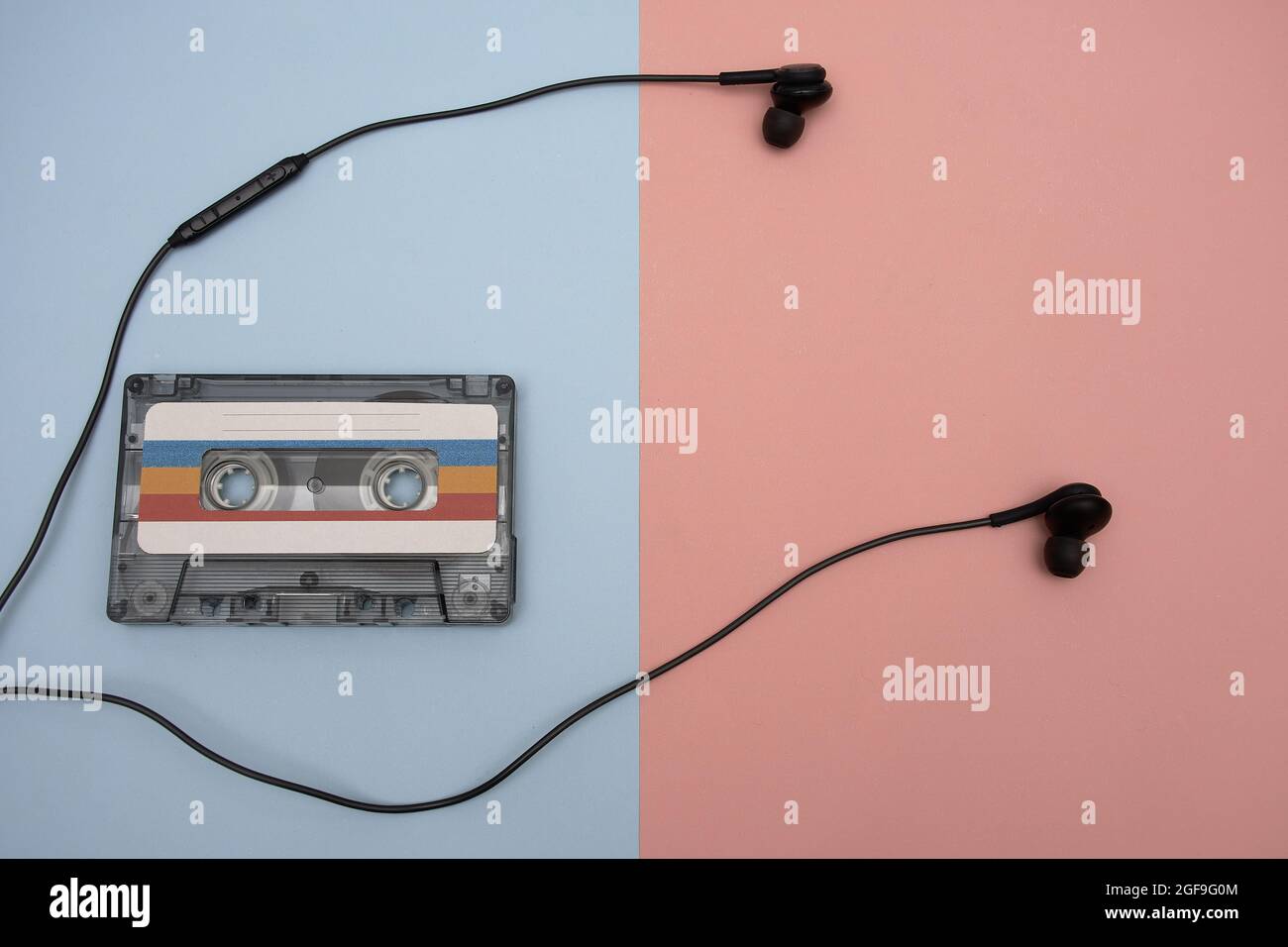 Colorful music cassette and headphones on light blue and light brow ...