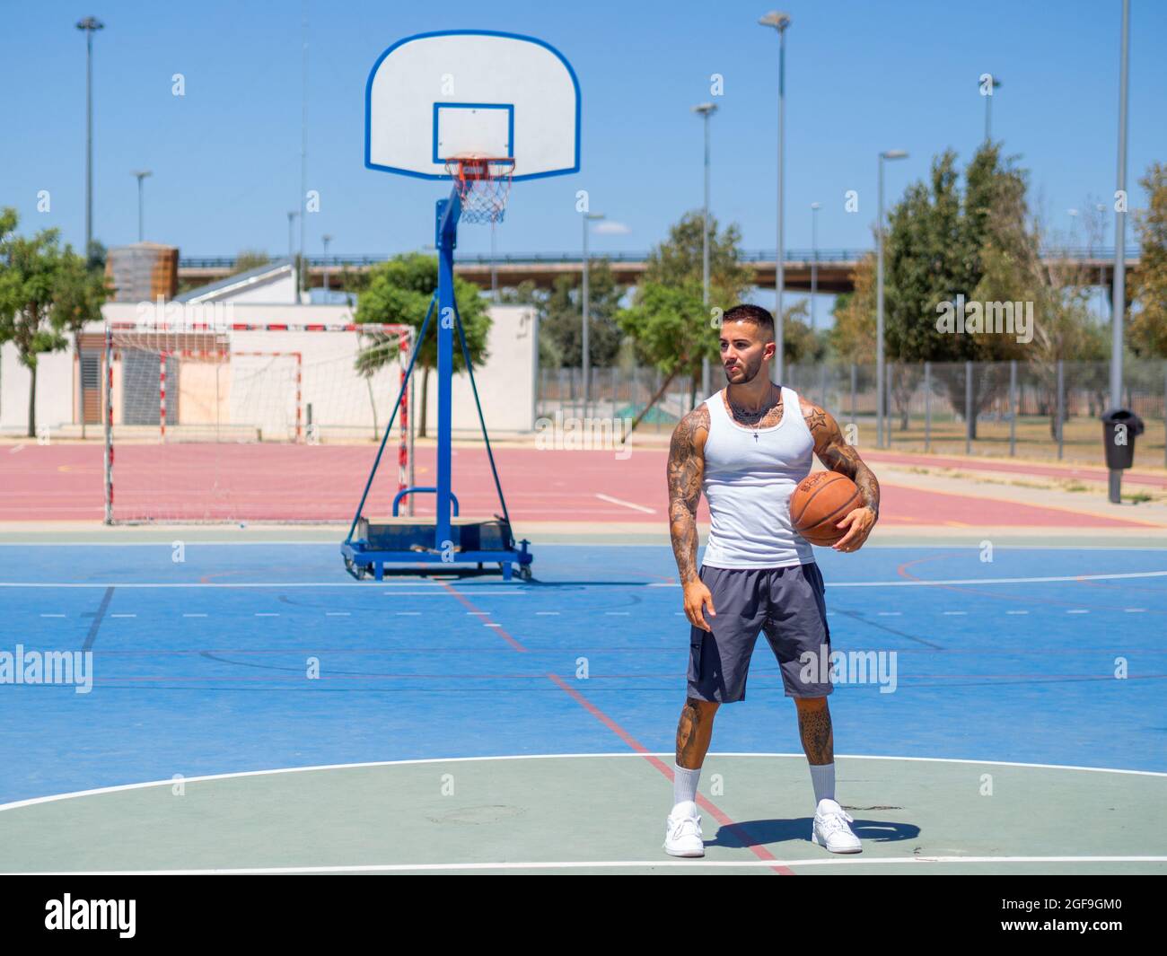 Athletic handsome Spanish basketball player training on a basketball ...