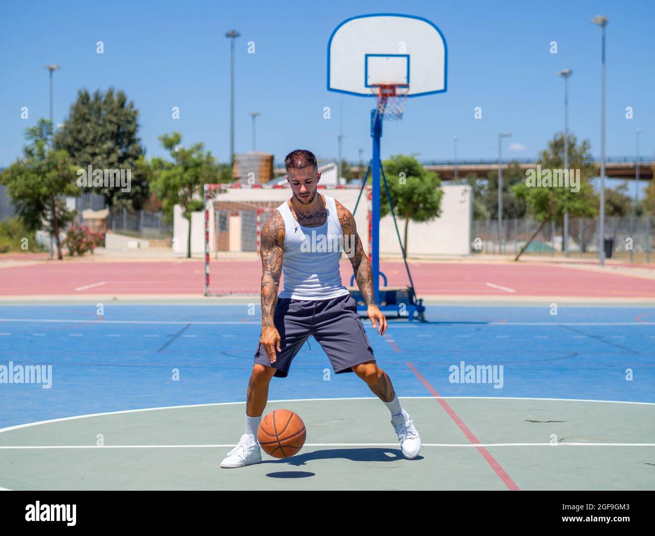 Athletic handsome Spanish basketball player training on a basketball ...