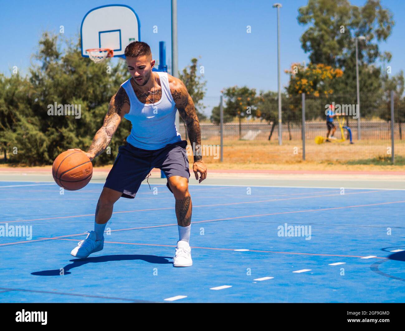 Athletic handsome Spanish basketball player training on a basketball ...