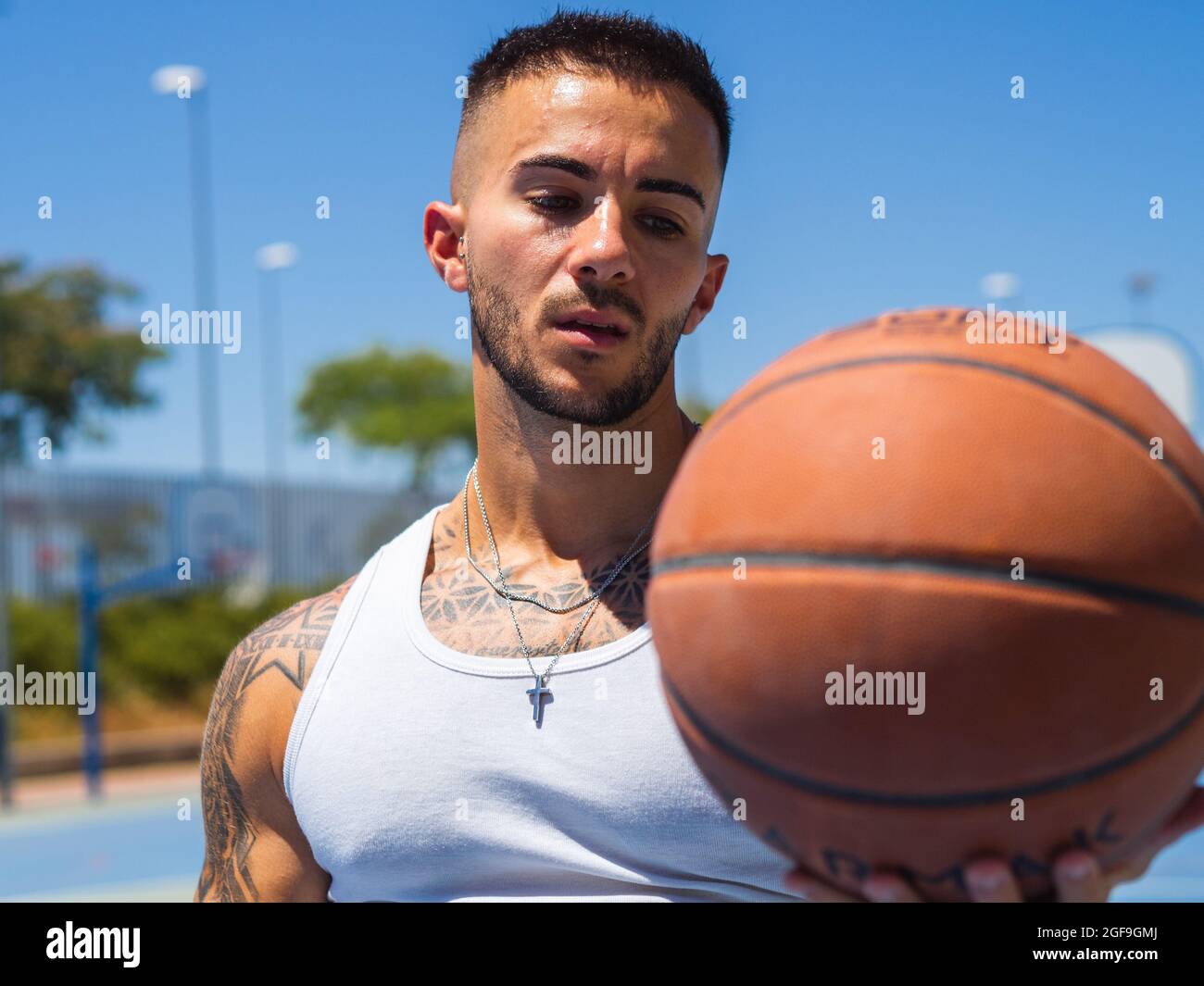 Athletic handsome Spanish basketball player training on a basketball ...