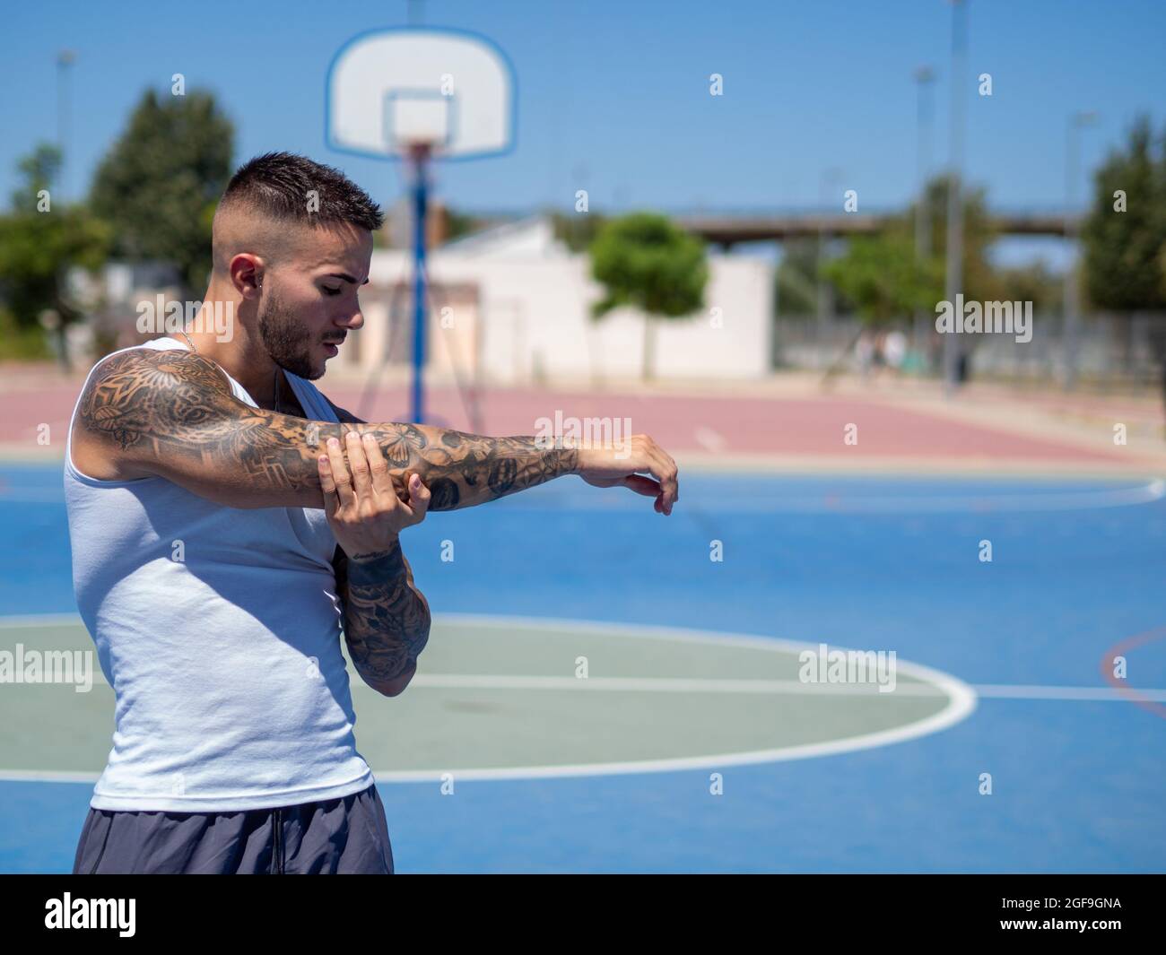 Athletic handsome Spanish basketball player training on a basketball ...