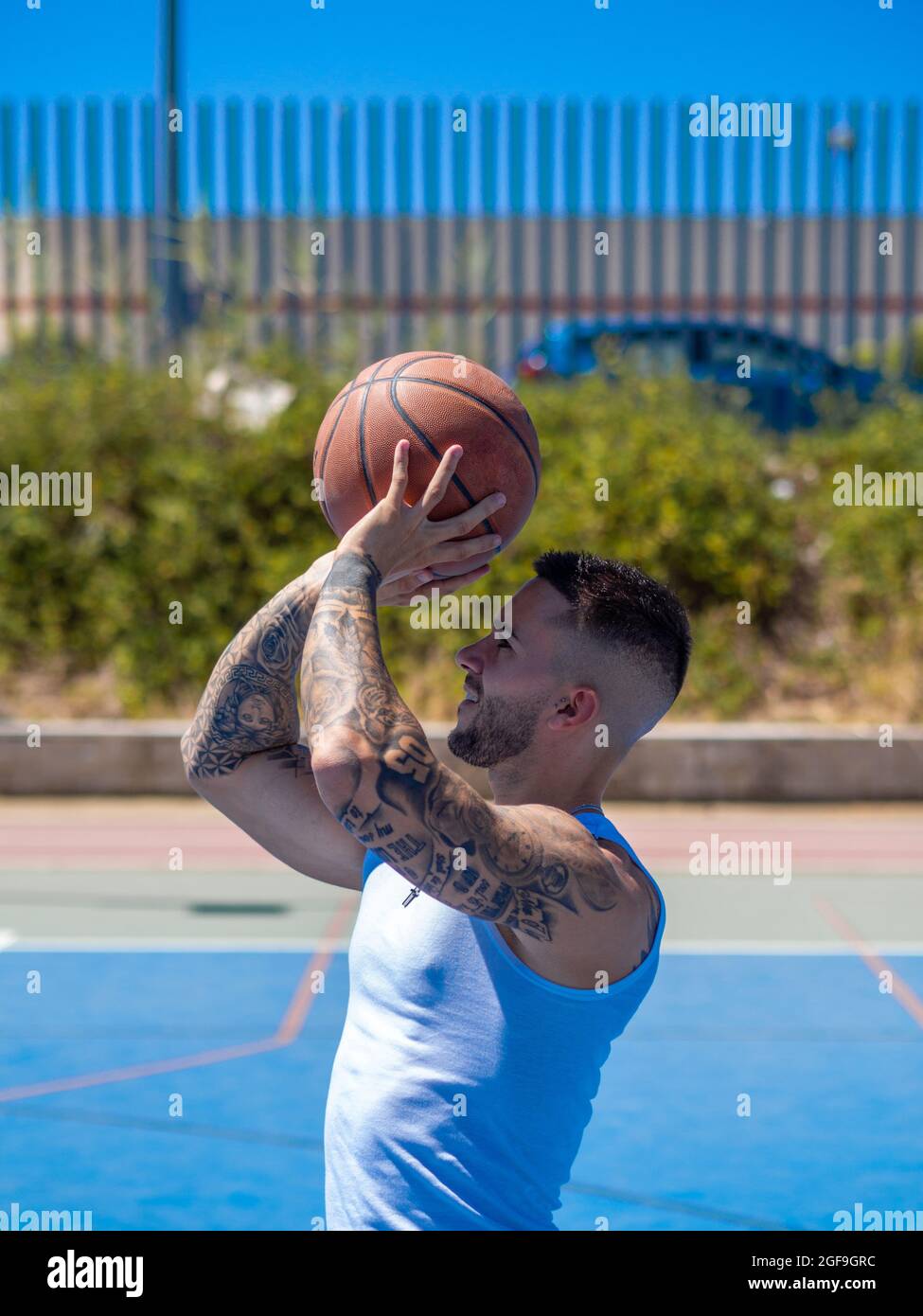 Athletic handsome Spanish basketball player training on a basketball ...